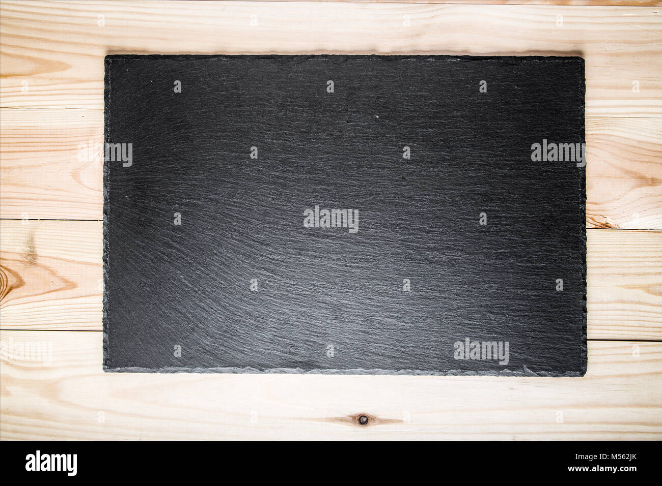 black slate board for serving on a light wood surface, top view Stock ...