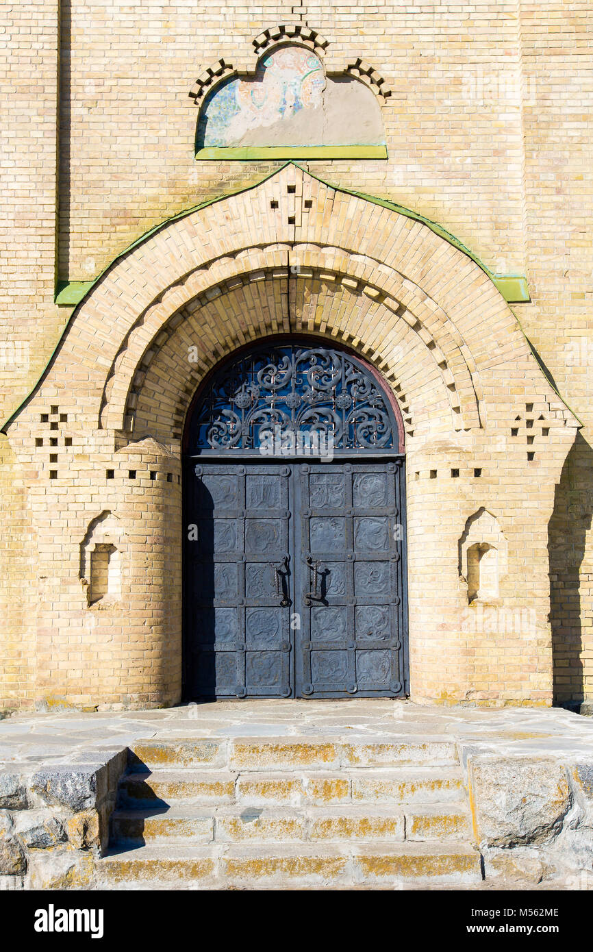 black metal gates of the ancient church. Stone stairs lead to the gate ...