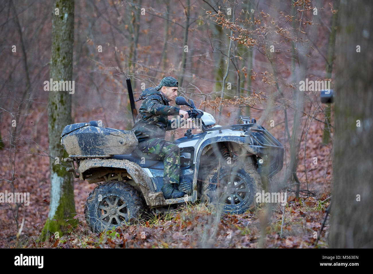 Young hunter on a quad bike searching for game in the forest Stock ...