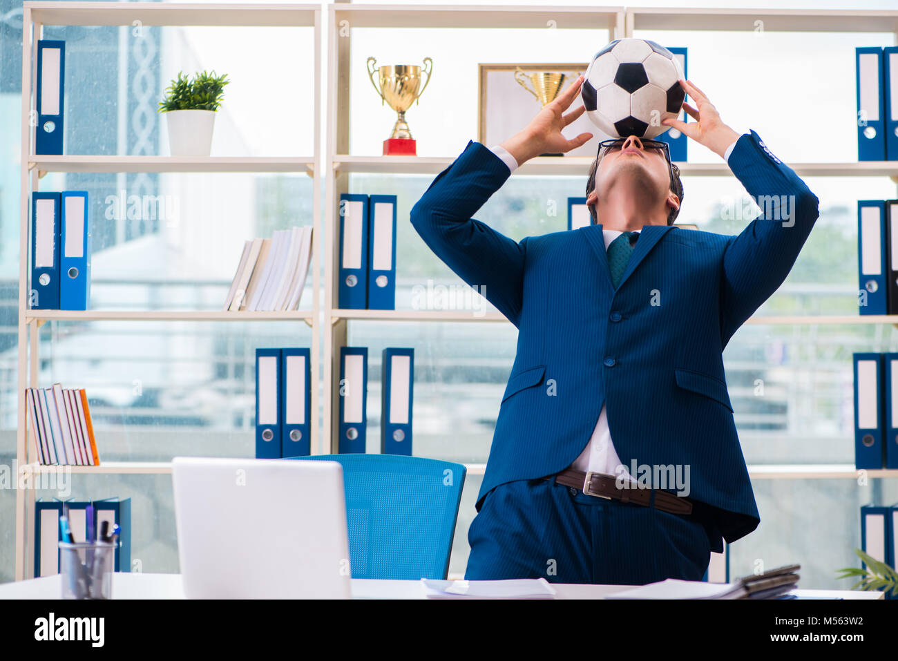Businessman playing football in the office Stock Photo - Alamy