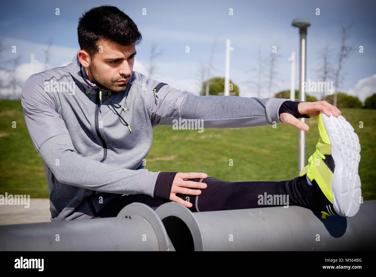 One young caucasian athletic man is preparing before running in a city ...