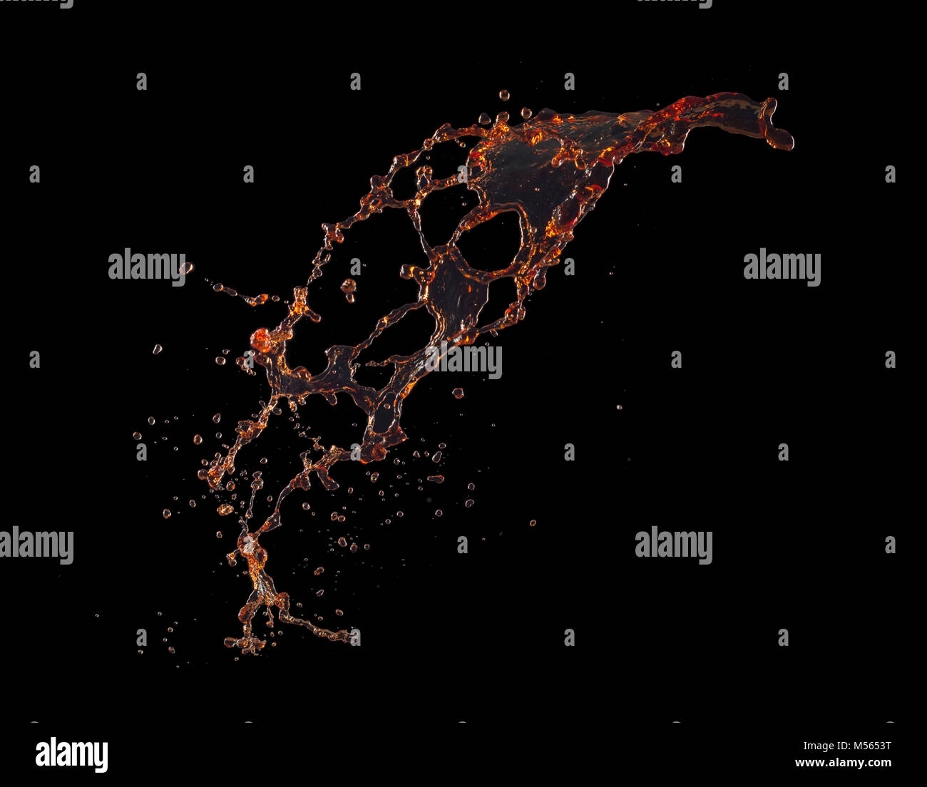 splash of ink isolated on black background. golden splash close-up ...