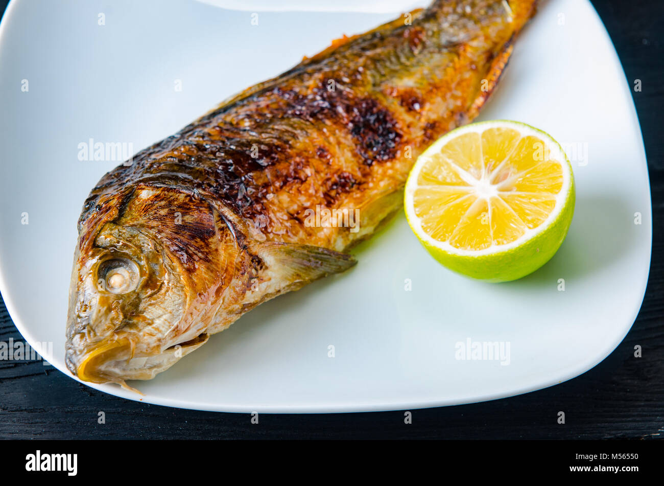Fried fish served on the plate Stock Photo - Alamy