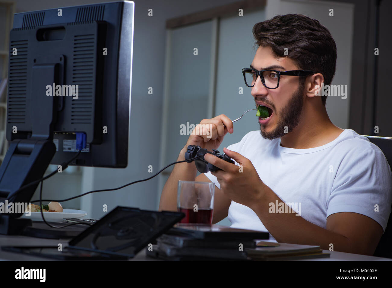 Young man playing games long hours late in the office Stock Photo - Alamy