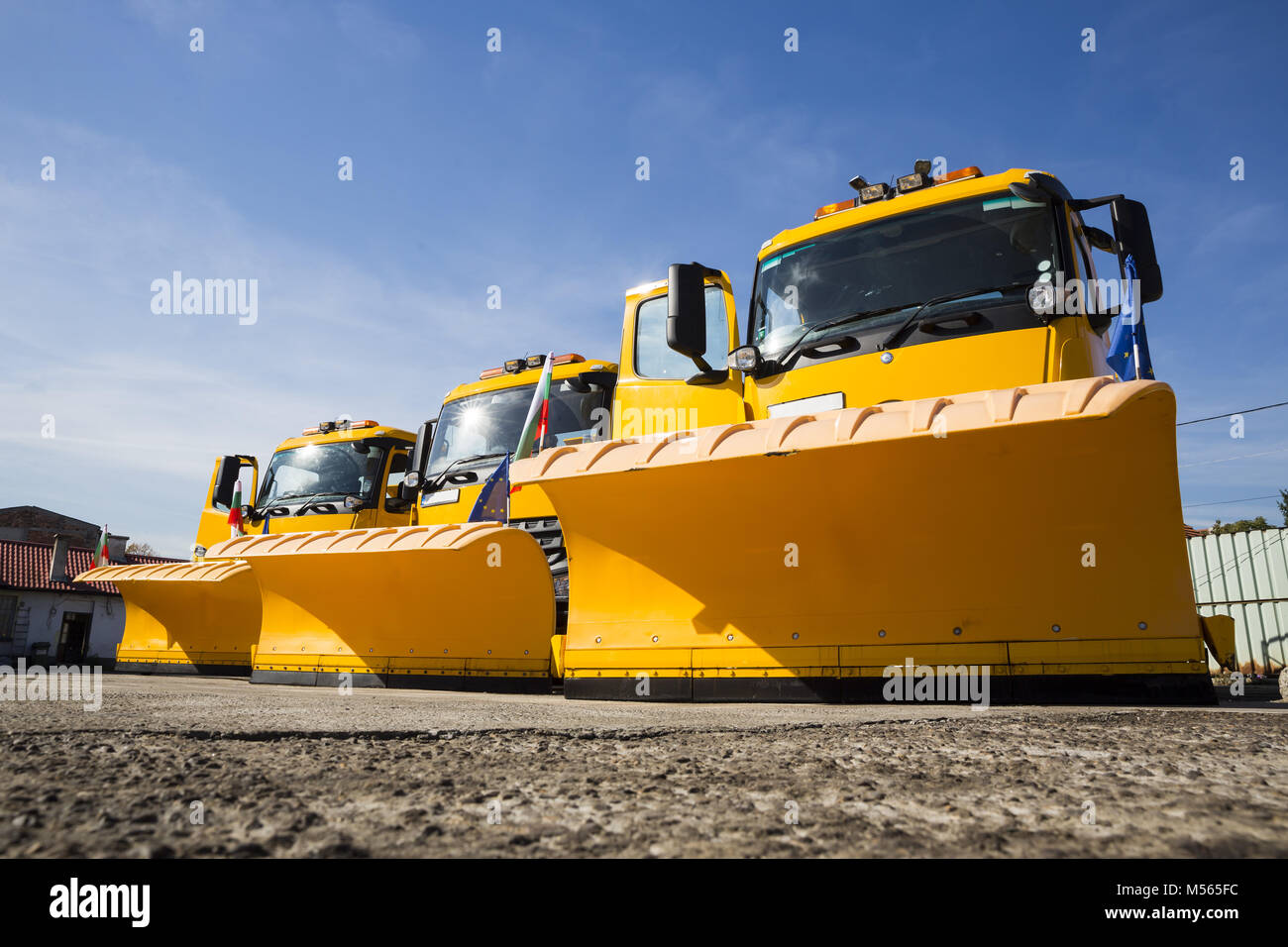 Yellow snowplow trucks in line Stock Photo - Alamy