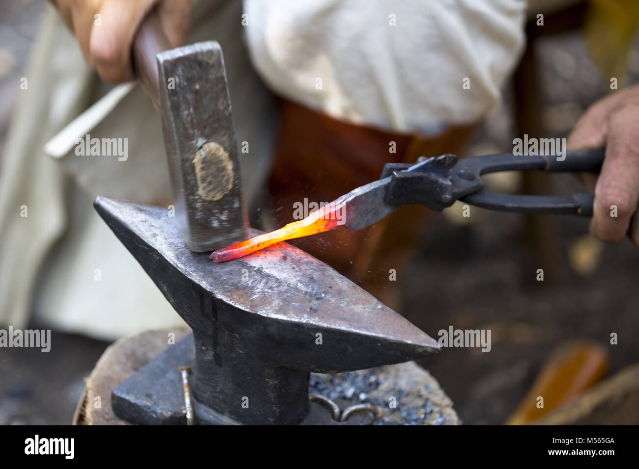 Blacksmith hammering hot metal arrow Stock Photo - Alamy