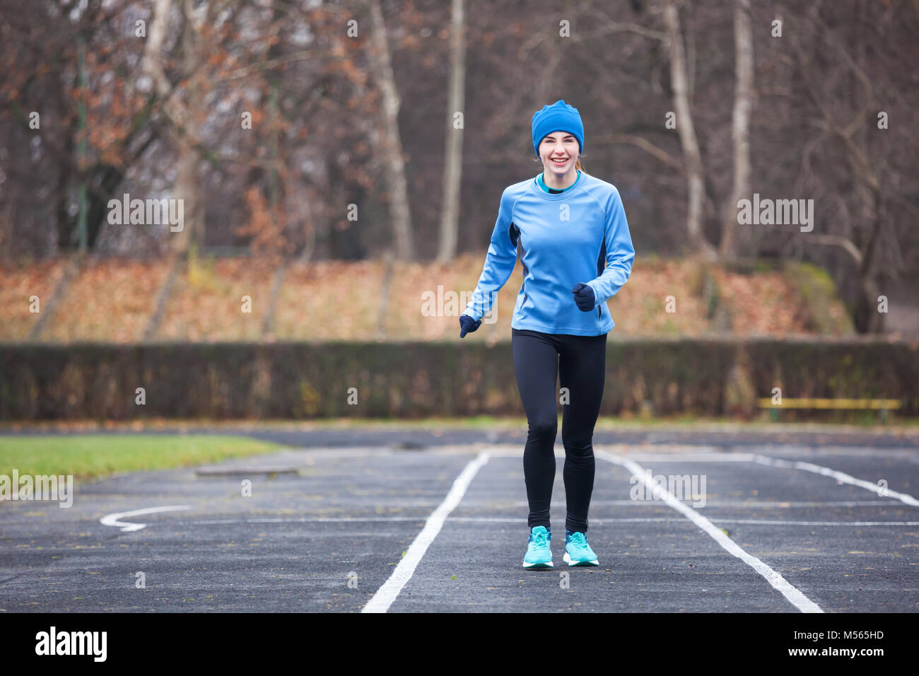 Full lenght shot of a young woman running on a stadium Stock Photo - Alamy