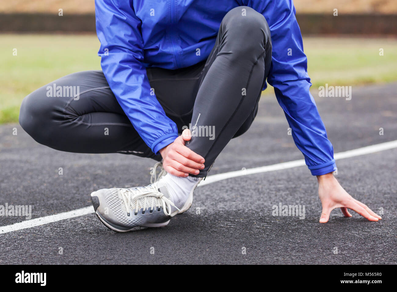 Cropped shot of a young man holding his ankle in pain while running ...
