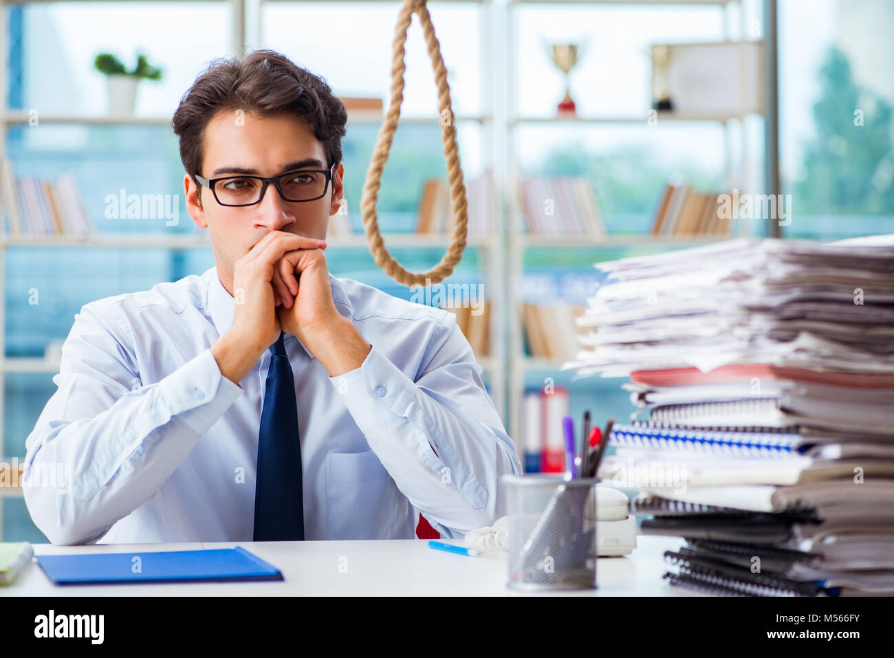 Unhappy businessman thinking of hanging himself in the office Stock ...
