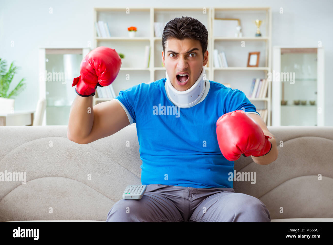 Man with neck injury watching boxing at home Stock Photo - Alamy