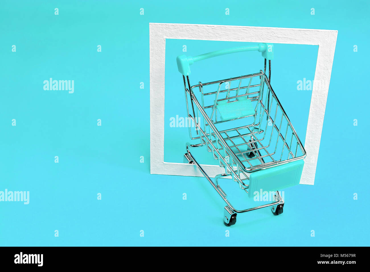 Blue shopping cart and canvas on the blue background Stock Photo - Alamy
