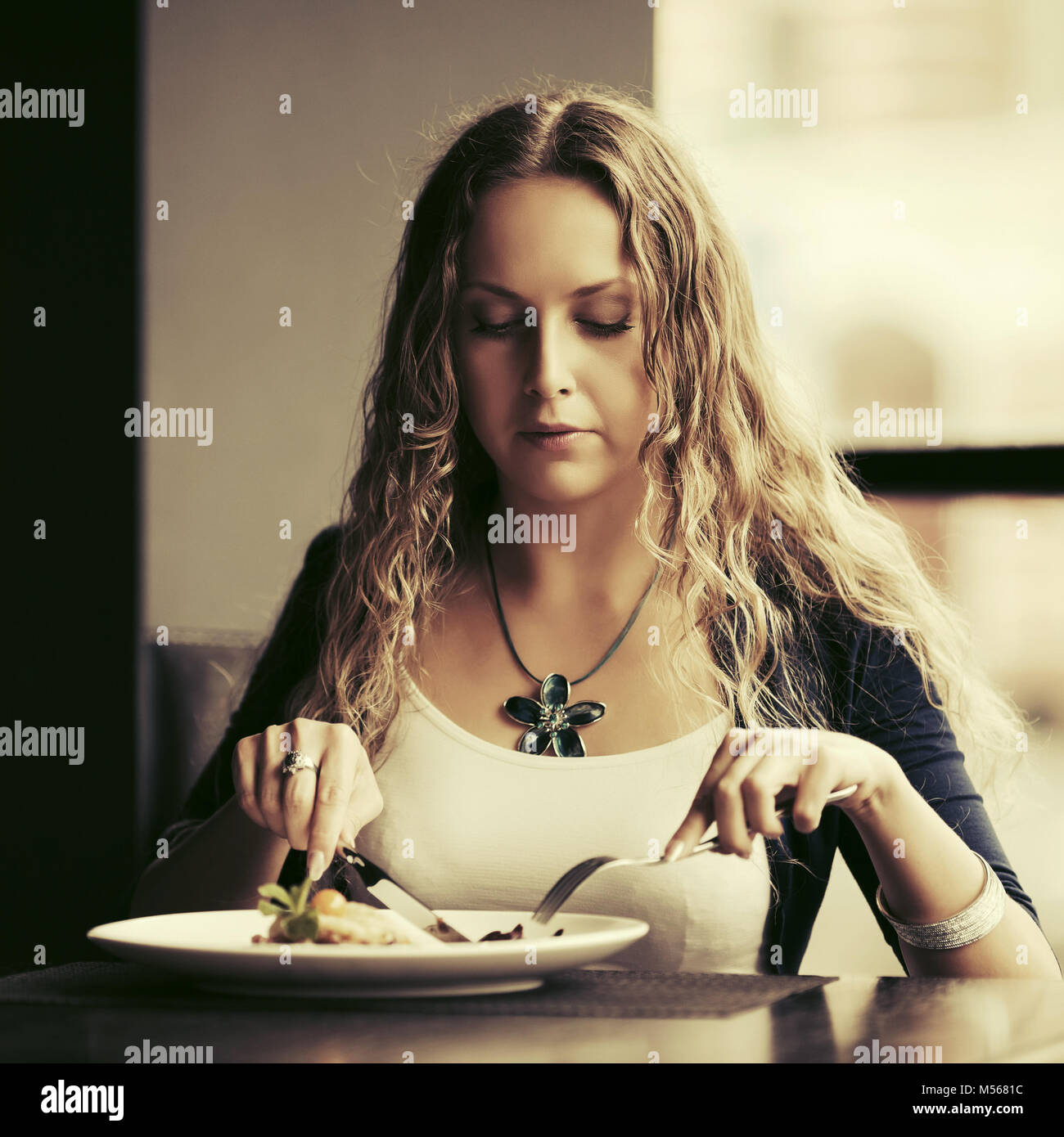 Beautiful young woman dining at restaurant Stock Photo - Alamy