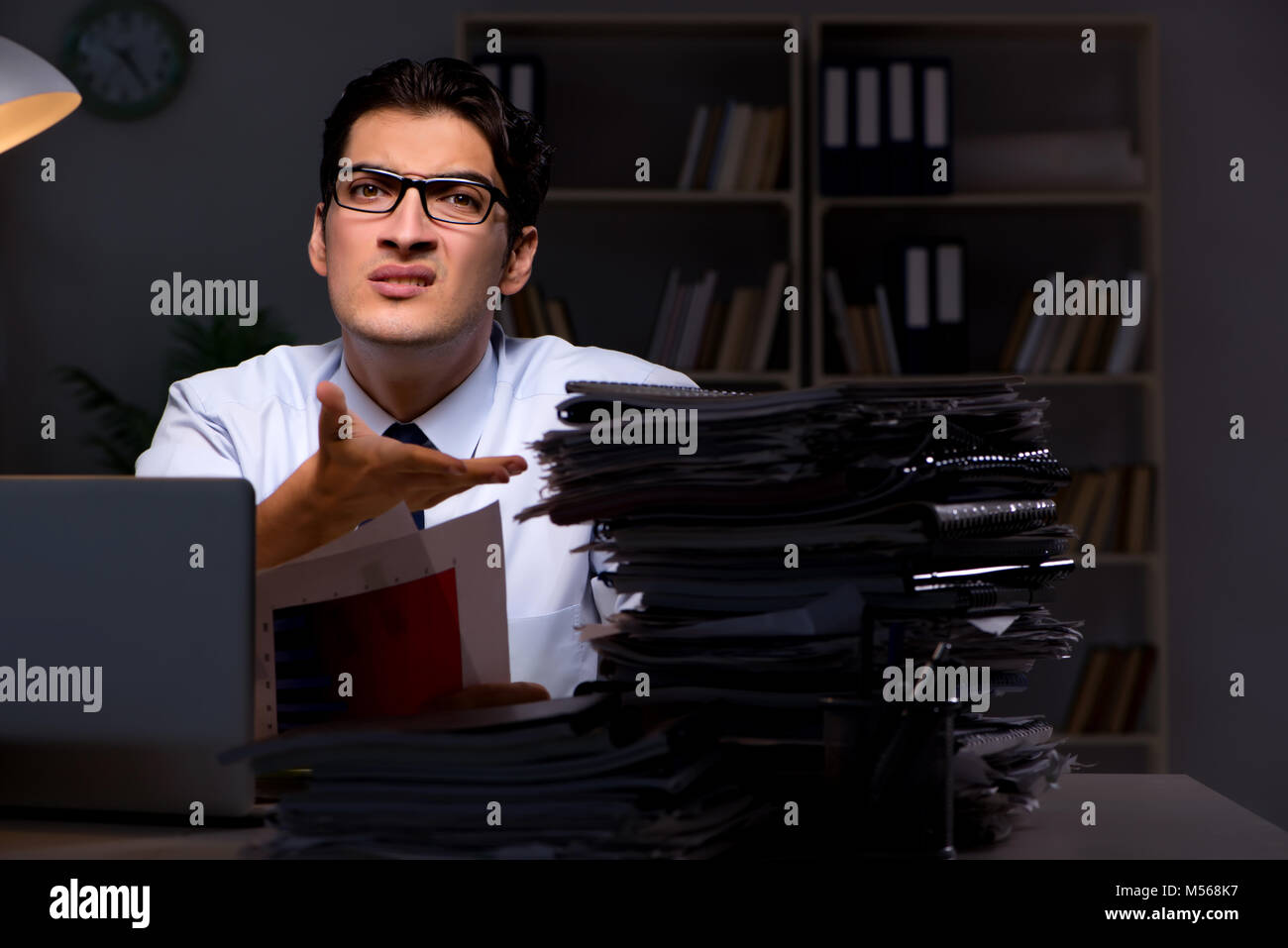 Young businessman working overtime late in office Stock Photo - Alamy
