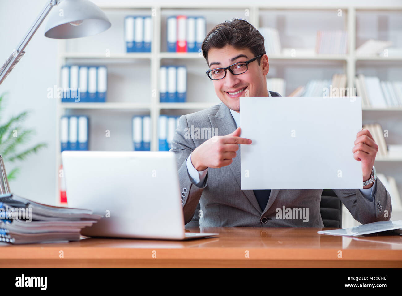 Businessman in office holding a blank message board Stock Photo - Alamy