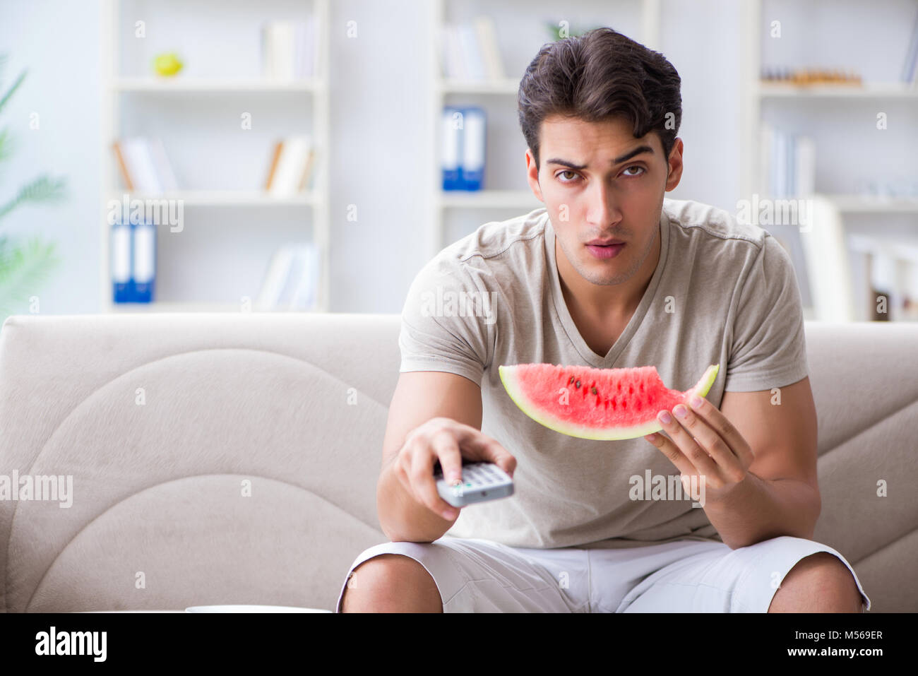 Man eating watermelon at home Stock Photo - Alamy