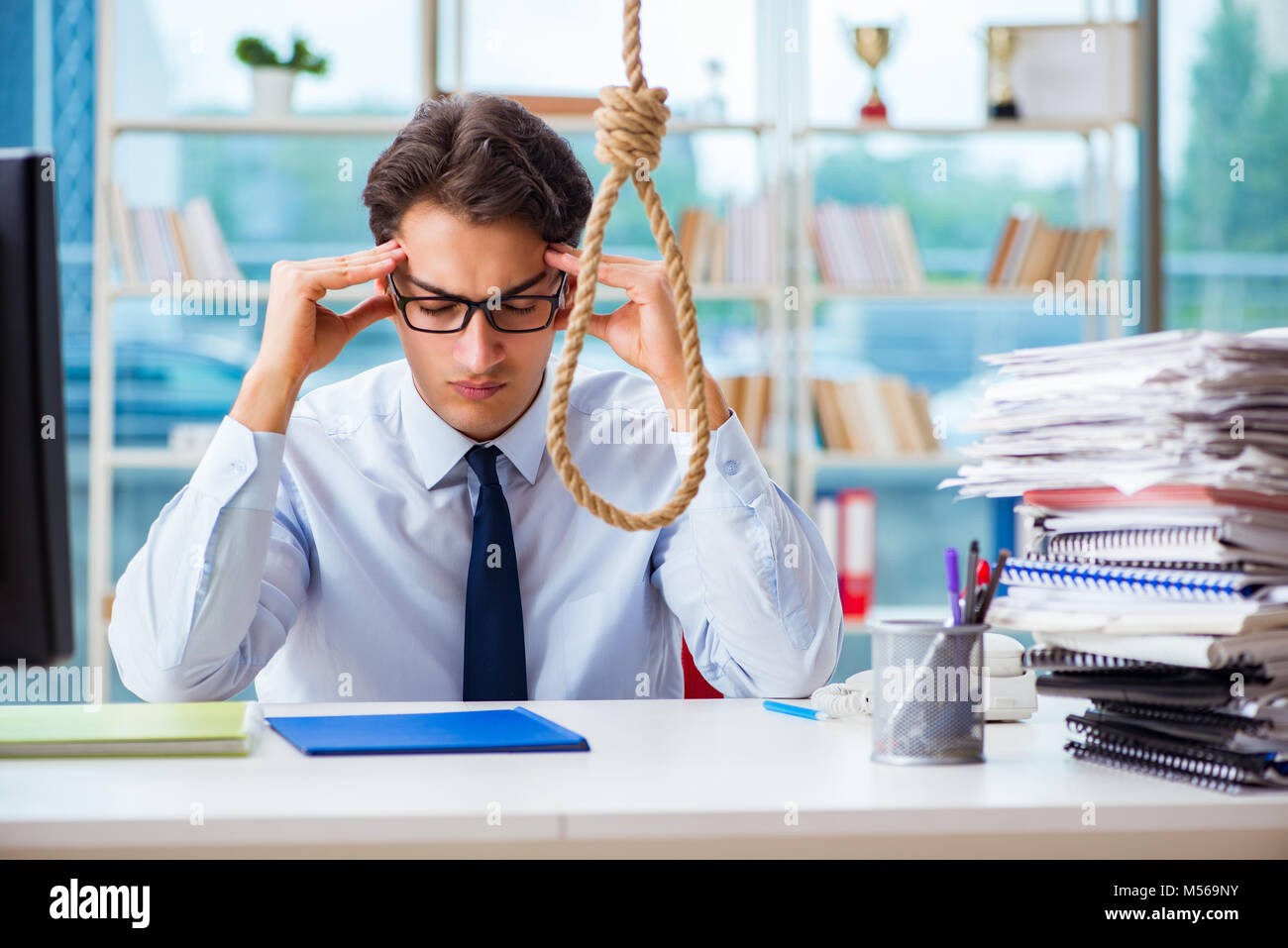 Unhappy businessman thinking of hanging himself in the office Stock ...
