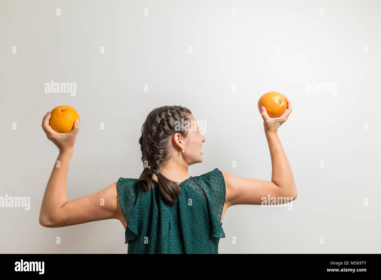 Strong woman tries to squeeze fruits with hands Stock Photo - Alamy