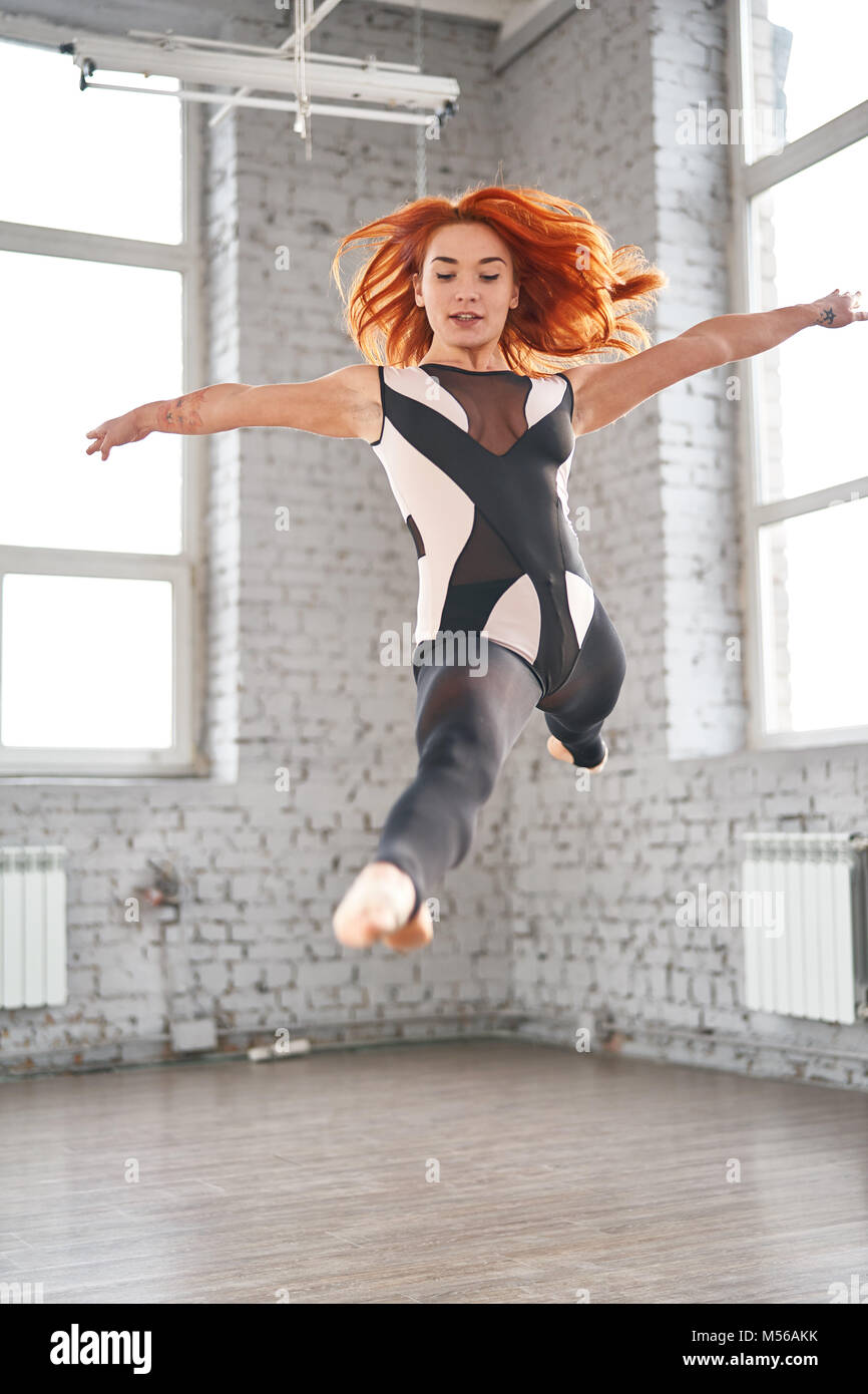 Young sport woman gymnastics doing jumping Stock Photo - Alamy