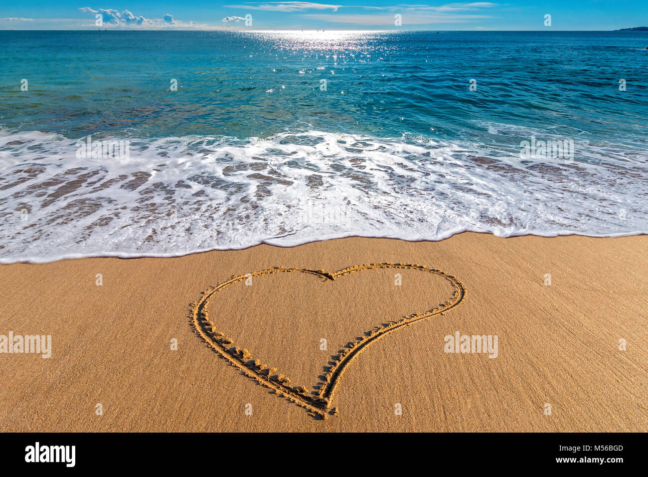 Drawing heart on the sand in the beach Stock Photo - Alamy