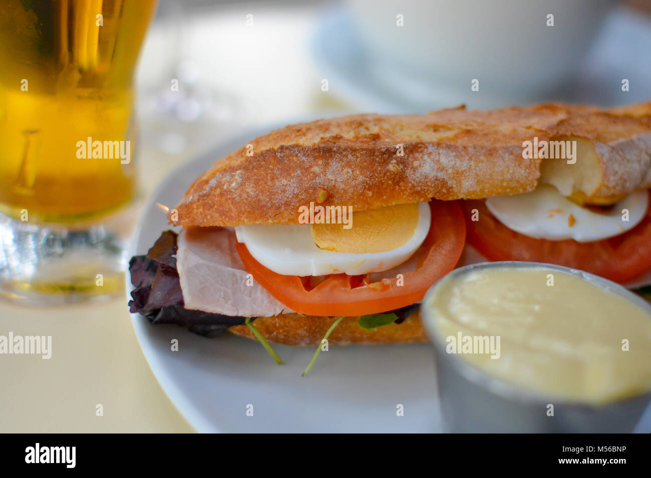 A ham club sandwich and beer at an outdoor cafe in Paris France with ...