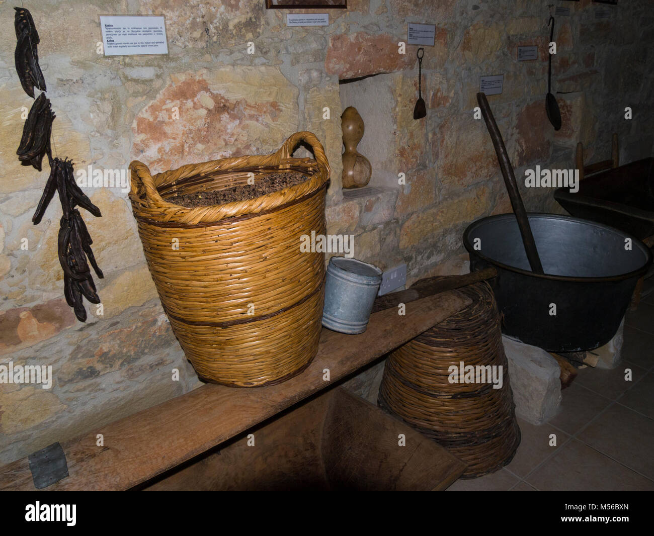 Basket full of carob and other utensils used in the production of carob ...