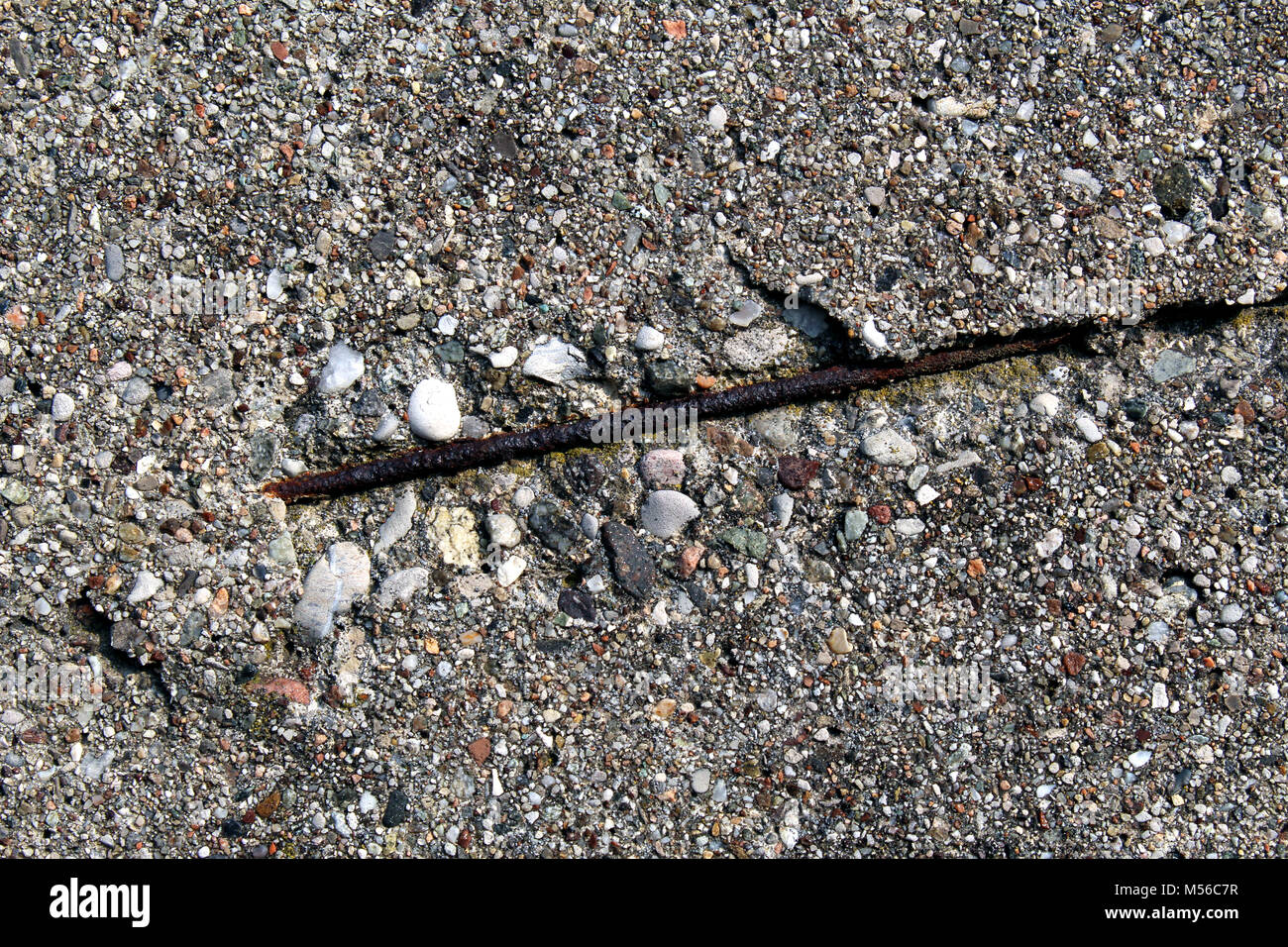 Rusty iron reinforcing bar (rod) emerging from an old concrete wall ...