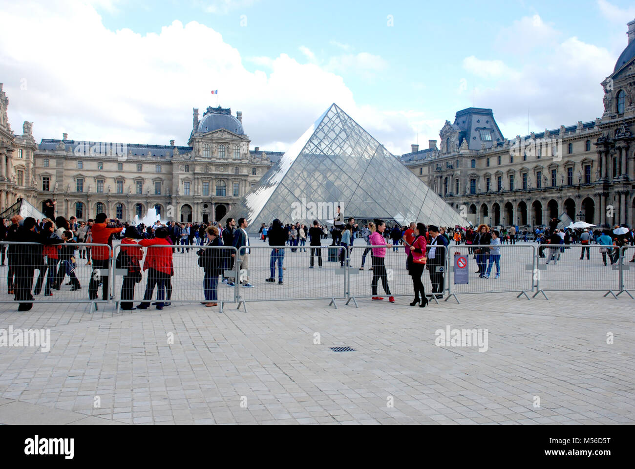 Glass pyramid in the main courtyard of Louvre Museum in a crowded day ...