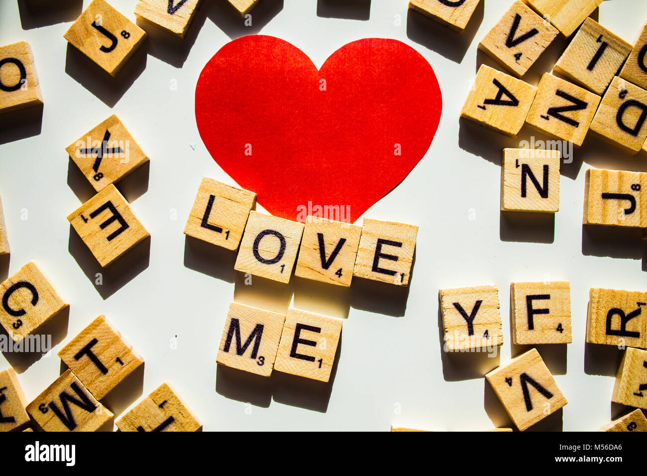 WORD LOVE ME. Wooden letters spelling the word LOVE ME on white ...