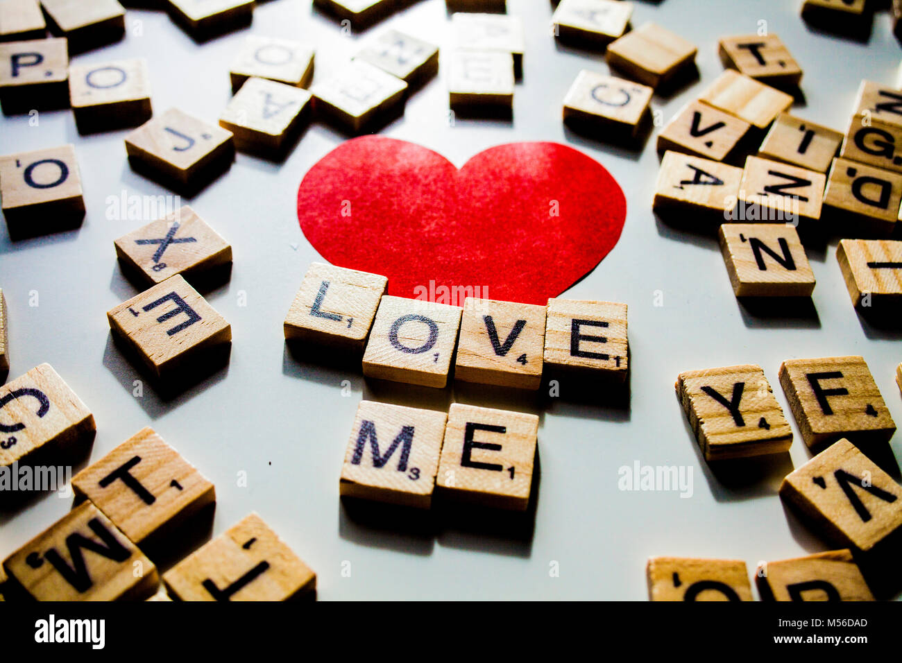 WORD LOVE ME. Wooden letters spelling the word LOVE ME on white ...