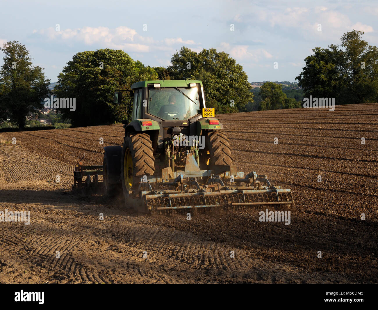 Farm tractor ploughing field in Derbyshire England Stock Photo - Alamy