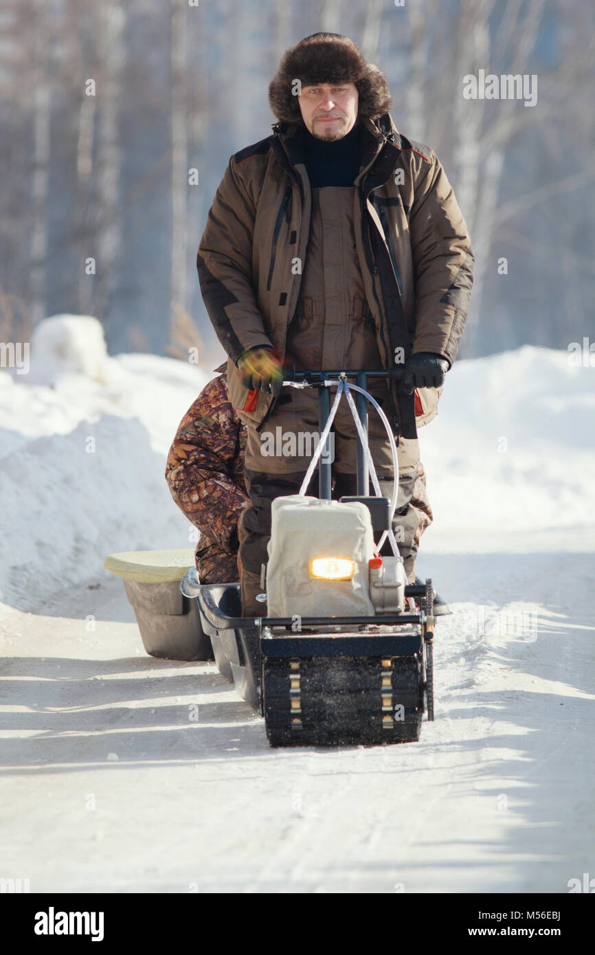 Compact snowmobile for hunting - motorcycle towing pulls cargo on snow ...