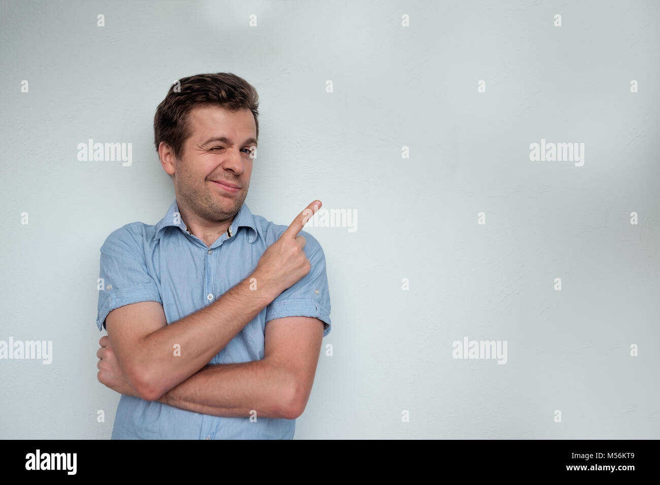 Pointing copy space. Confident mature man pointing away and smiling ...