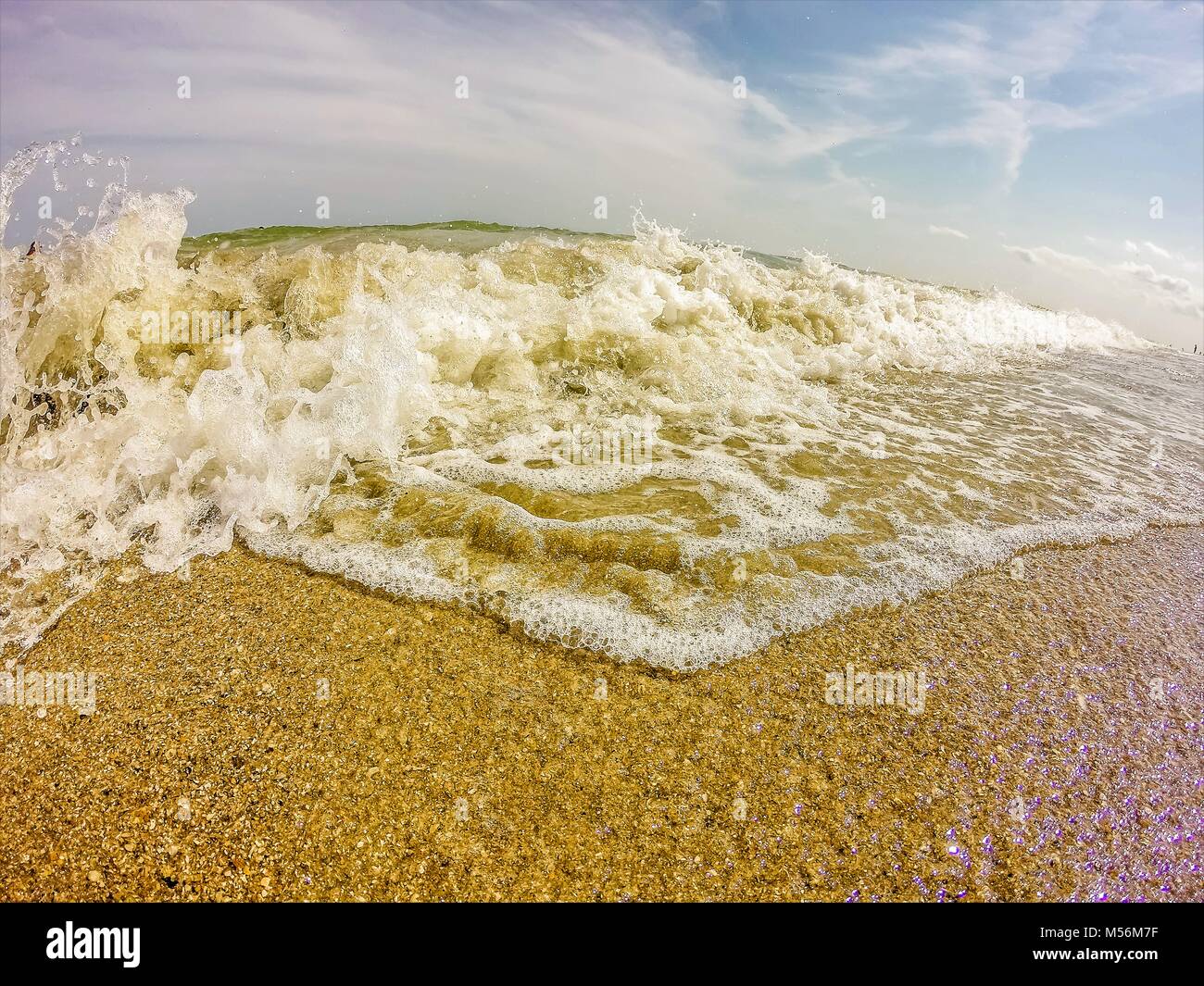 ocean waves crashing onto sandy beach shores Stock Photo - Alamy