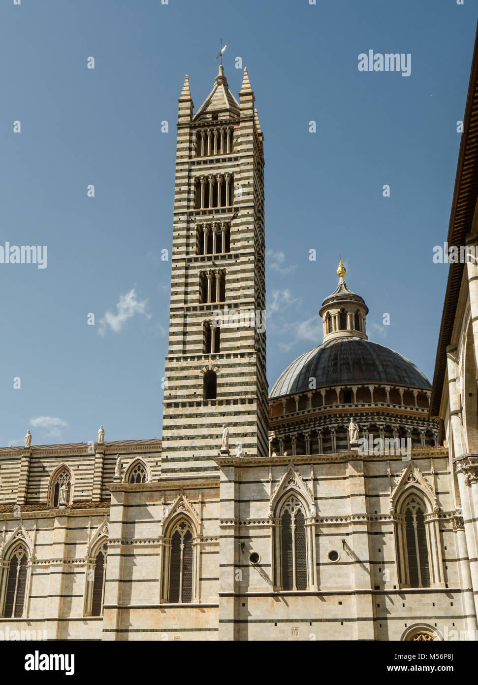 Exterior of Siena Cathedral with cupola next to the black and white ...