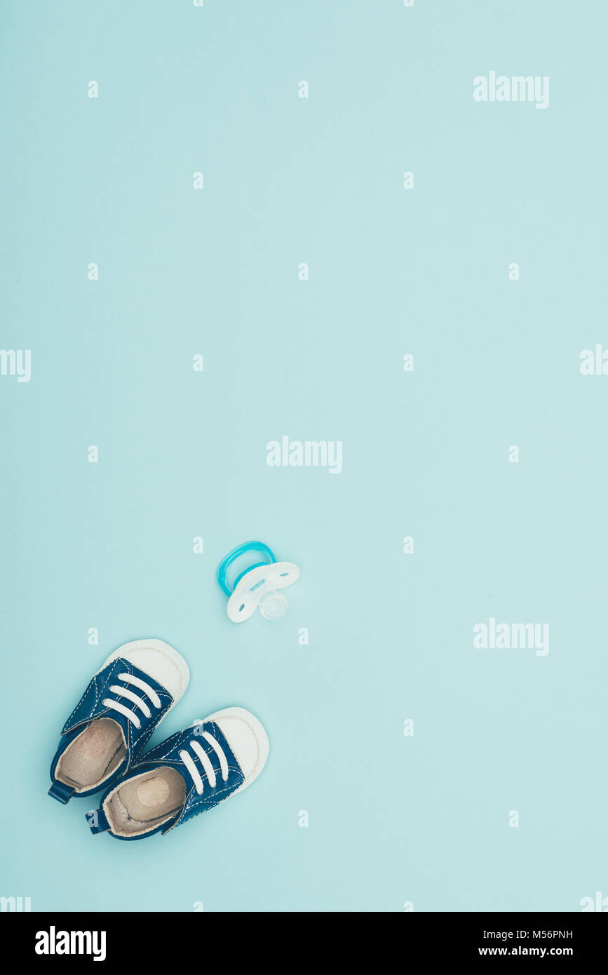 top view of baby shoes and dummy isolated on blue Stock Photo - Alamy