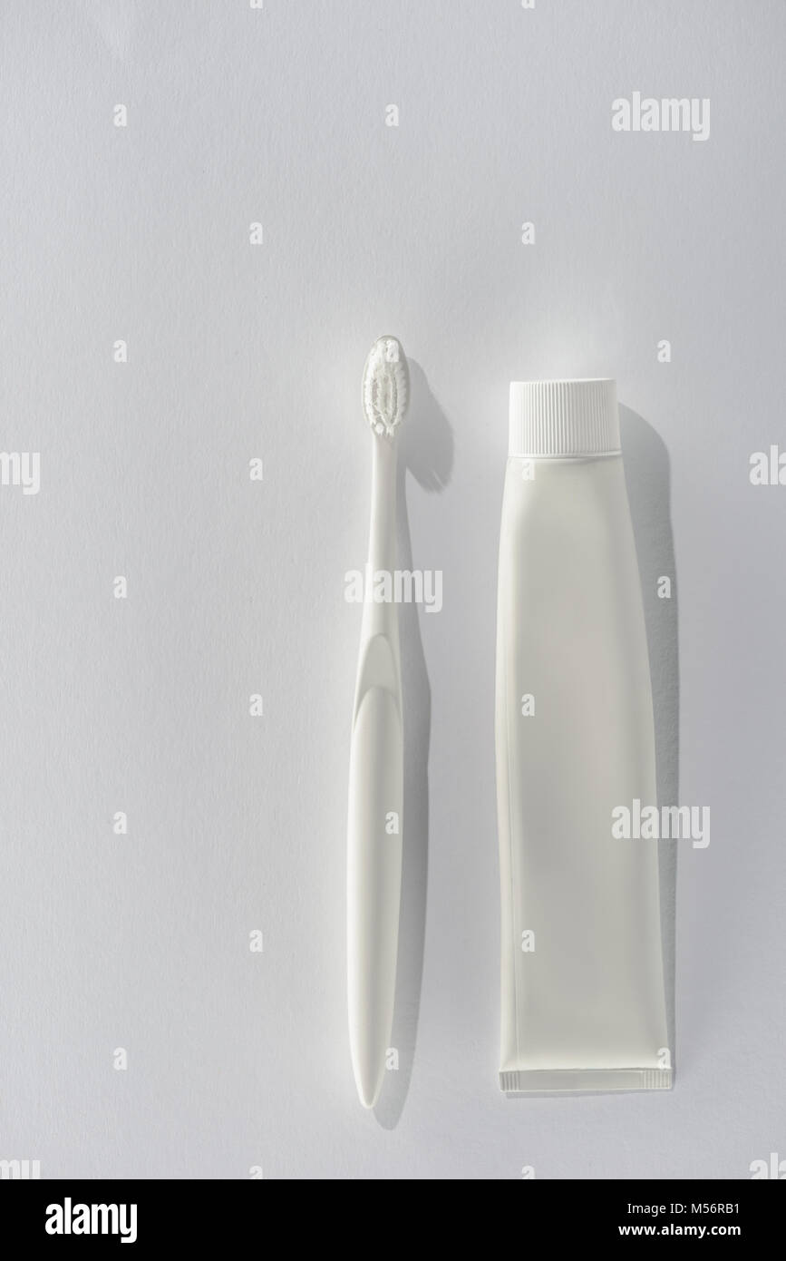 top view of white toothbrush and tube of toothpaste, on white Stock ...