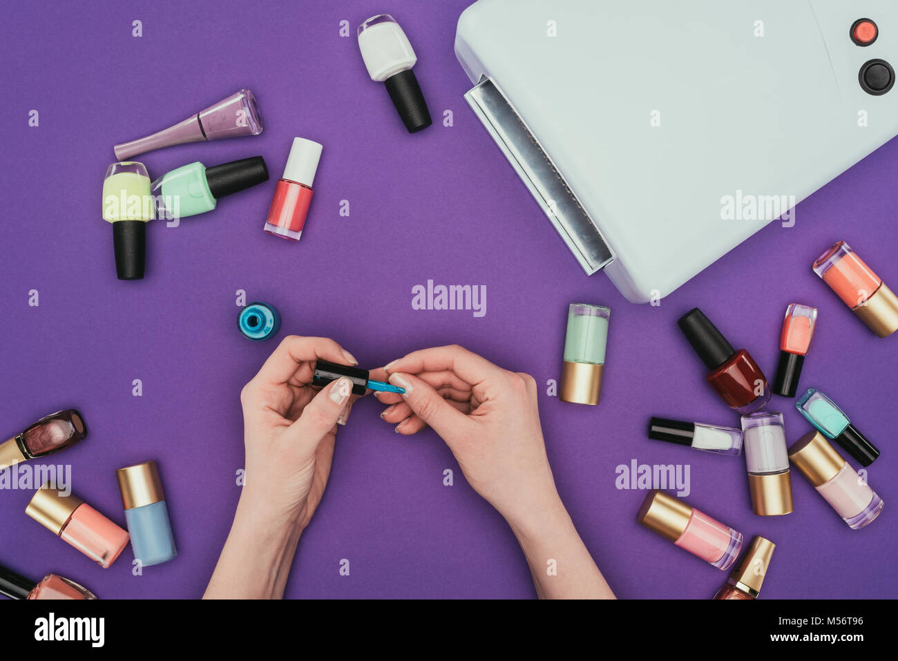 cropped image of girl painting nails isolated on purple Stock Photo - Alamy