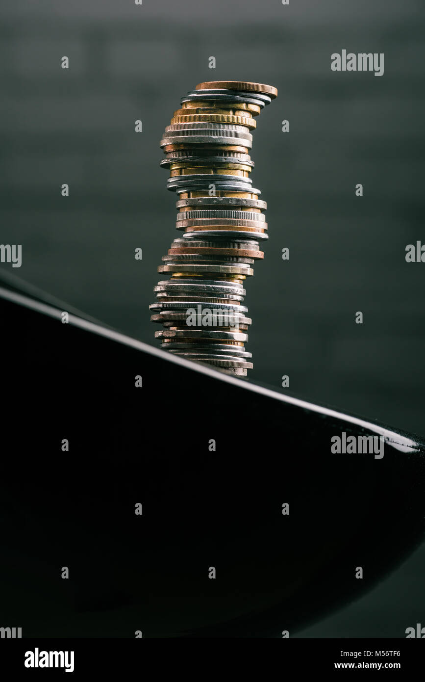 close up view of stack of different coins standing on edge of table ...