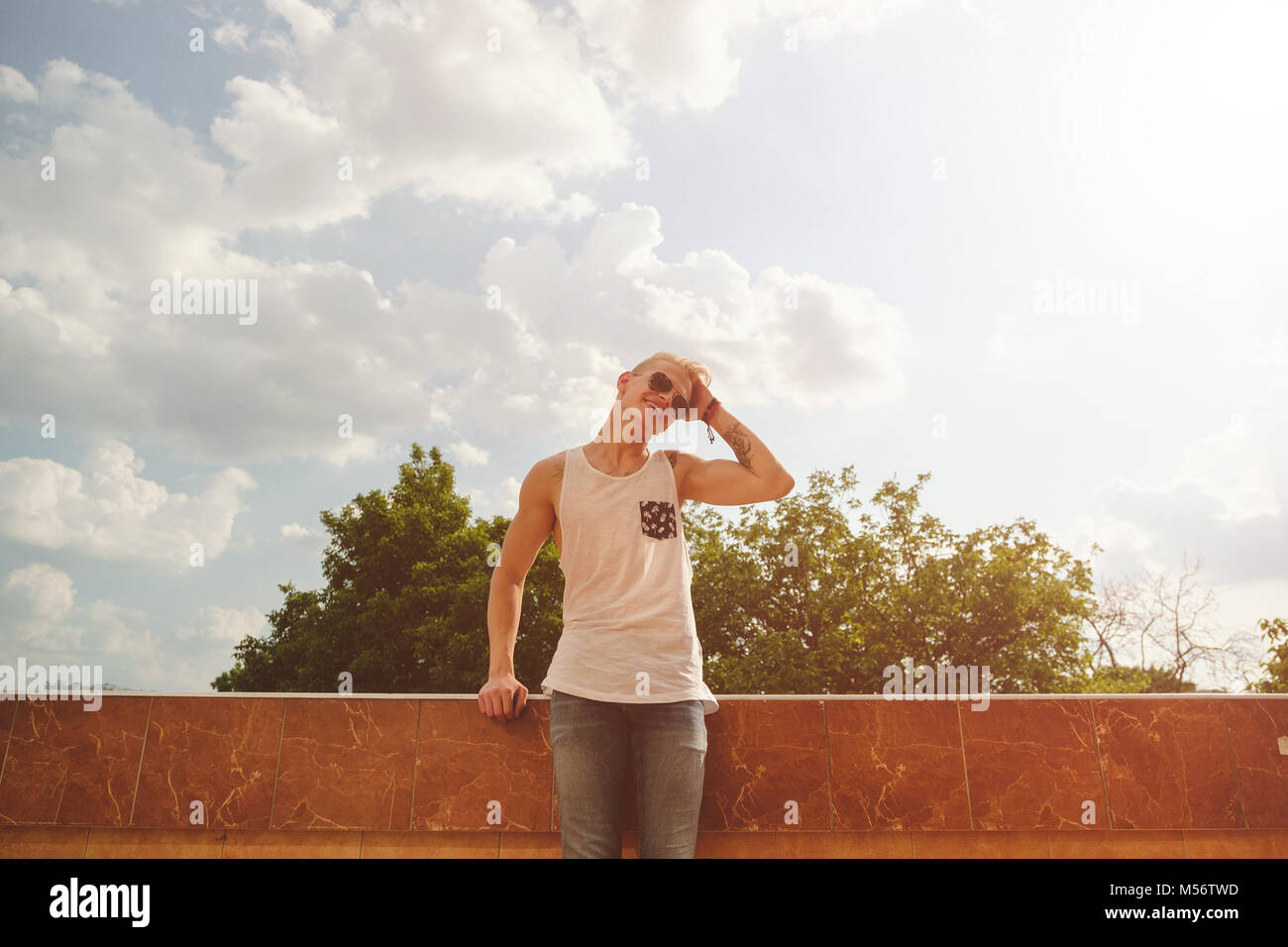 Young man relaxing, enjoying a sunny day while standing on a bui Stock ...