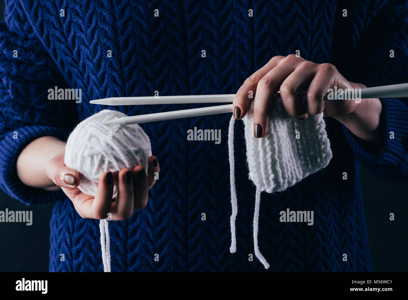cropped view of female hands with knitting needles and white wool Stock ...