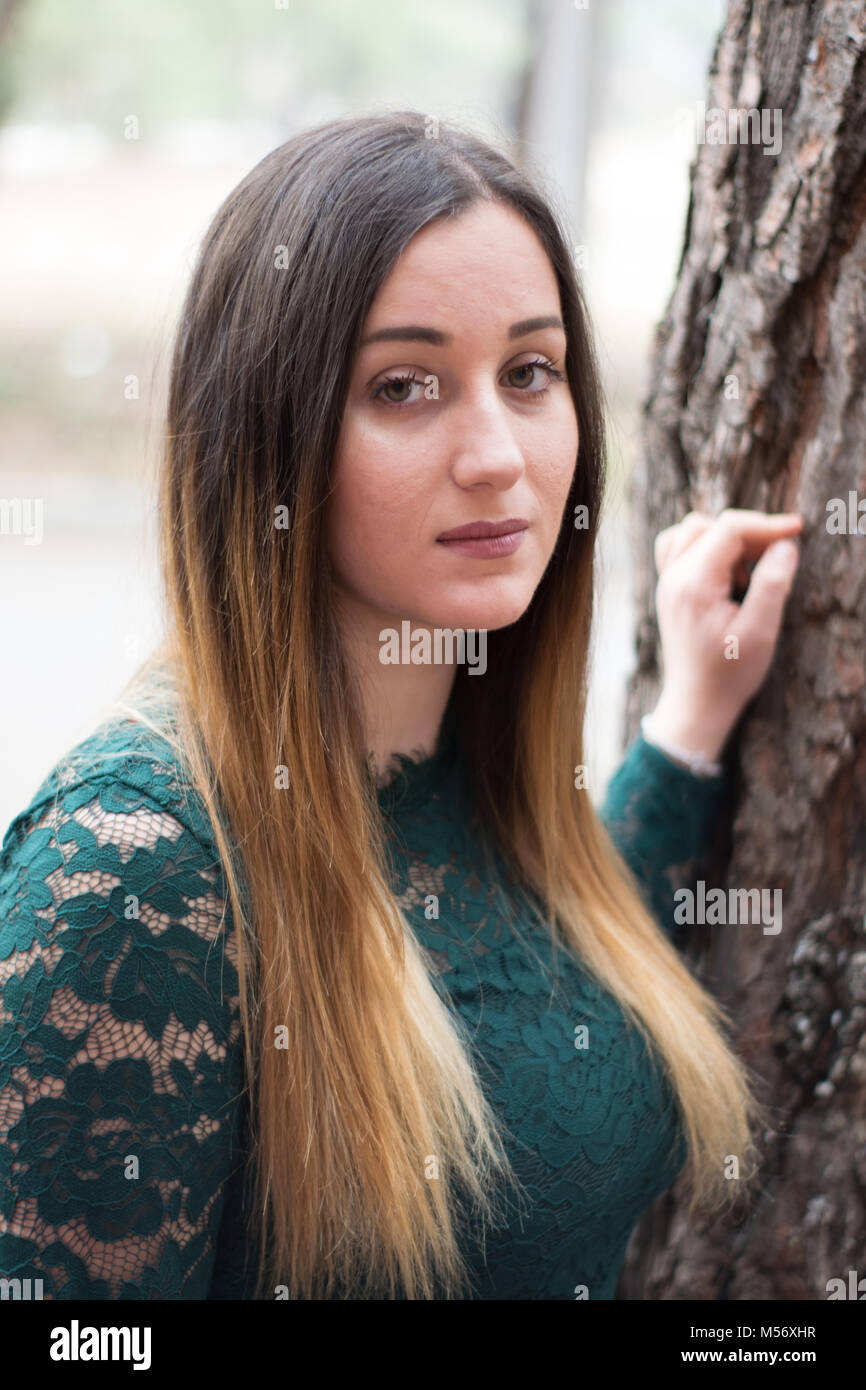 Portrait of woman next to tree Stock Photo - Alamy