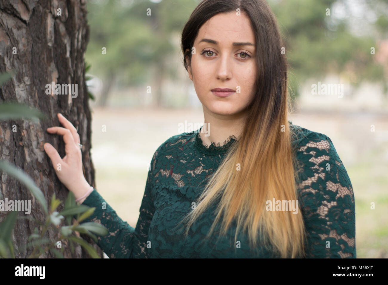 Portrait of woman next to tree Stock Photo - Alamy