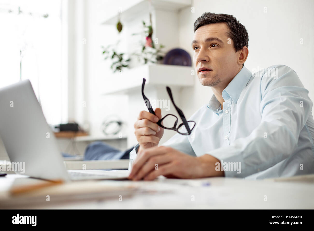 Thoughtful employer working on his laptop Stock Photo - Alamy