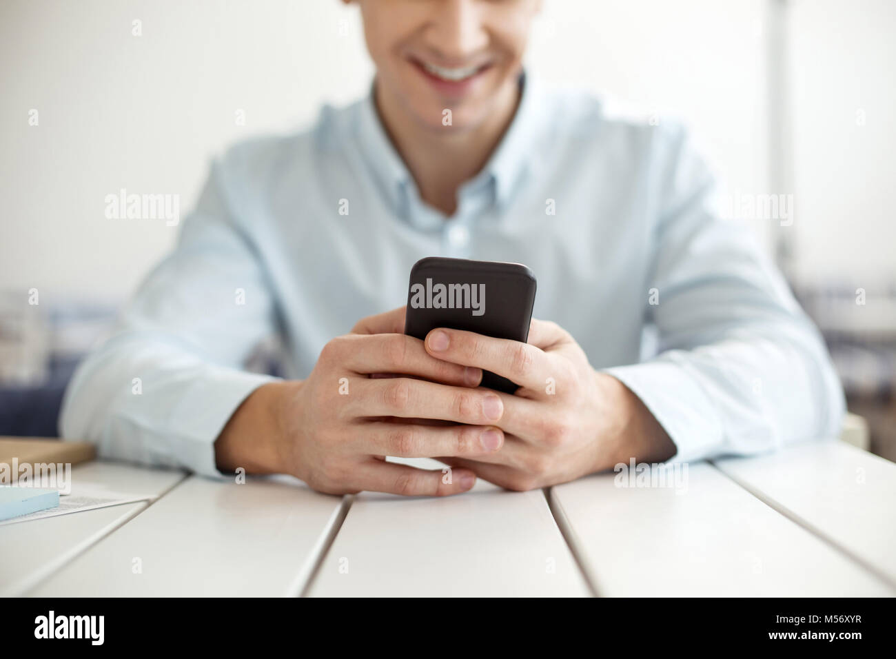 Smiling man typing on a modern phone Stock Photo - Alamy