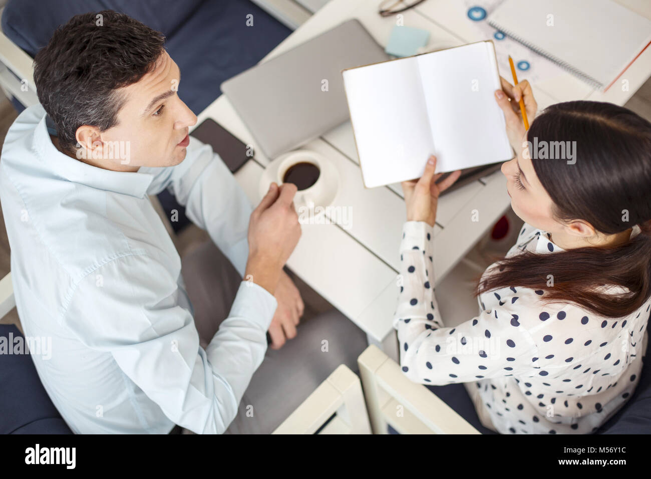 Concentrated co-workers discussing work at the table Stock Photo - Alamy