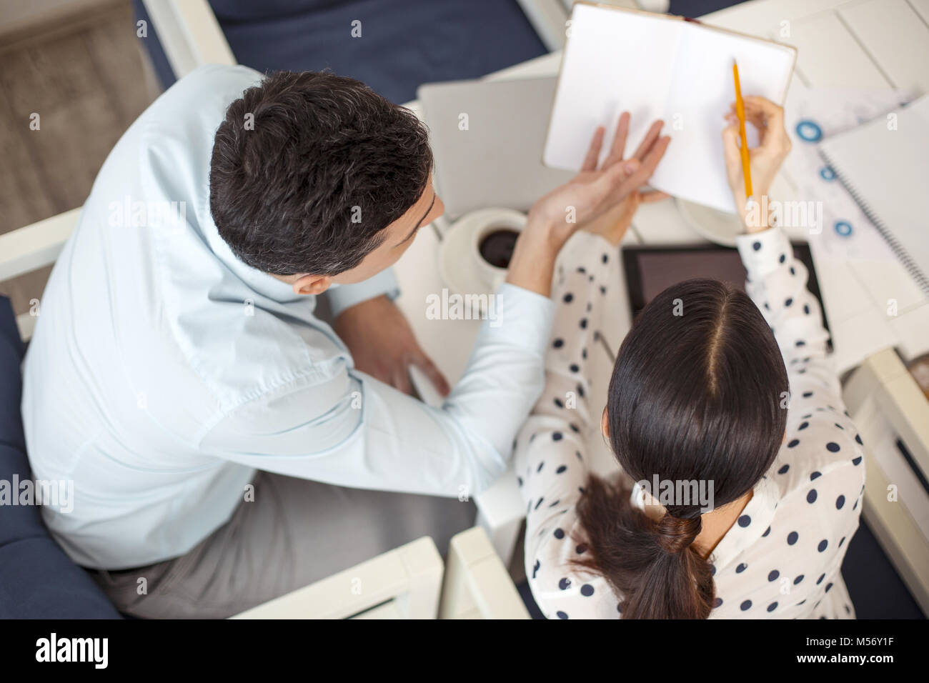 Determined co-workers discussing work at the table Stock Photo - Alamy