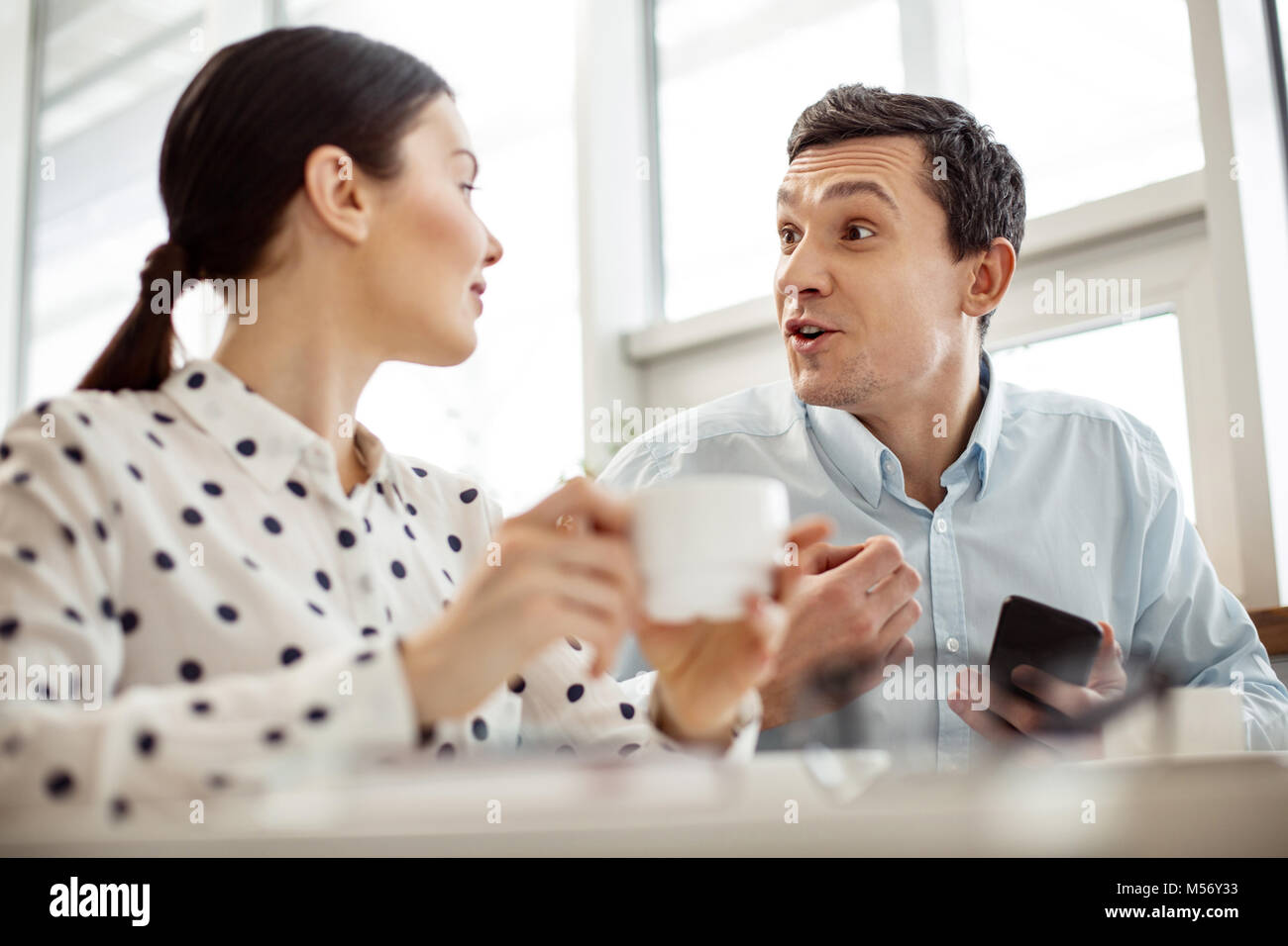 Excited man talking to his co-worker Stock Photo - Alamy