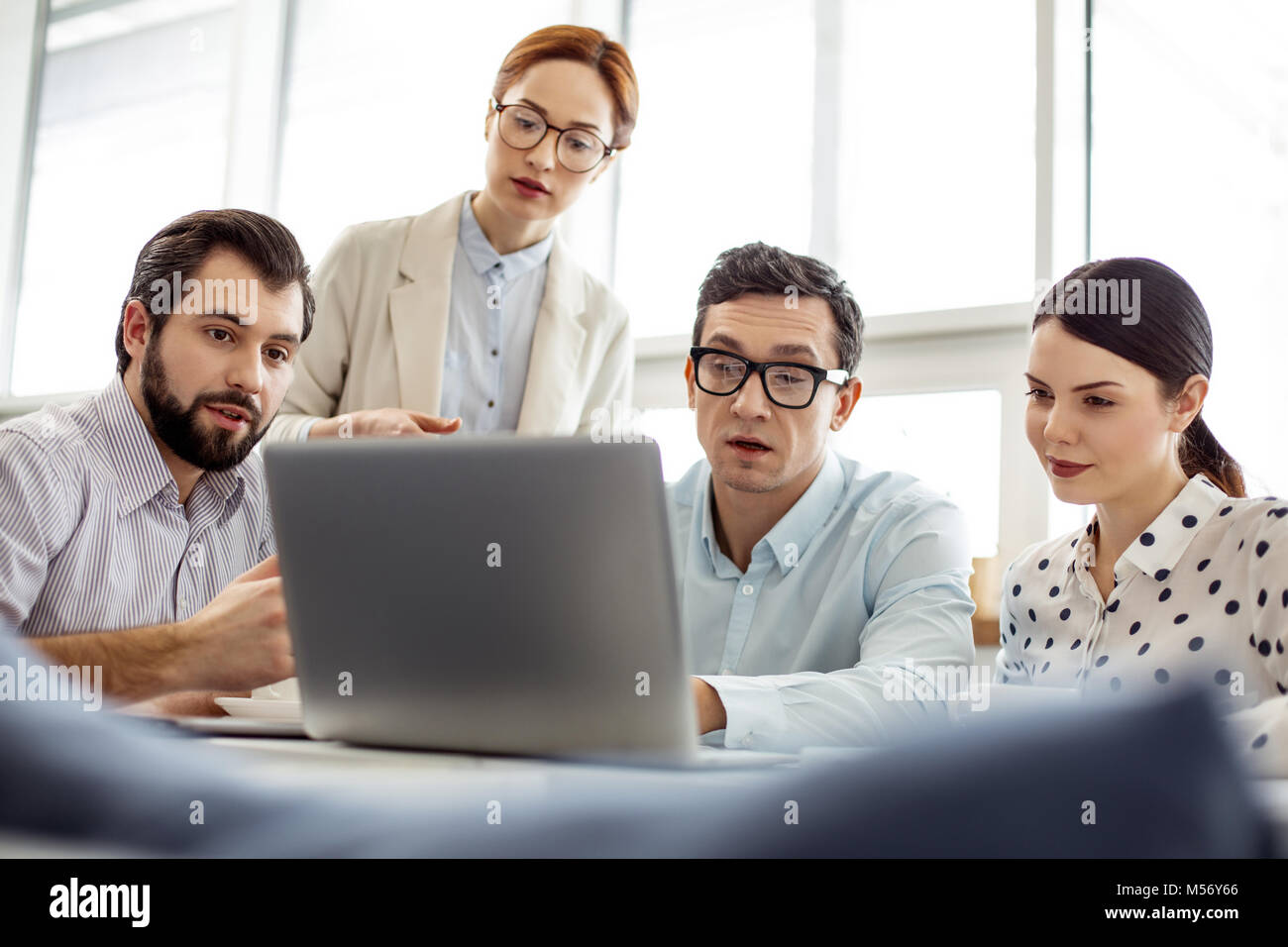 Concentrated man working on a project with his team Stock Photo - Alamy