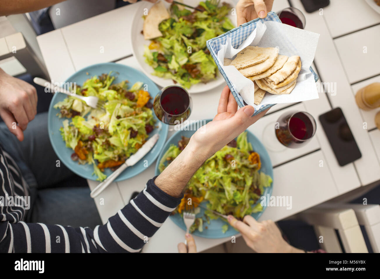 Man offering tasty slices of bread while having dinner Stock Photo - Alamy