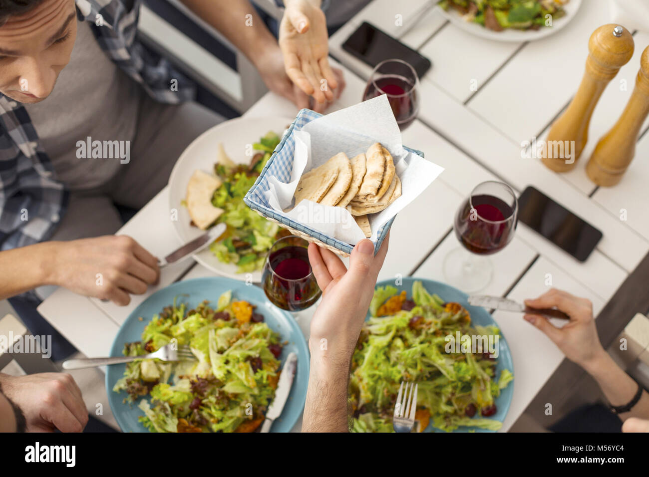 Man passing some bread to his friends Stock Photo - Alamy